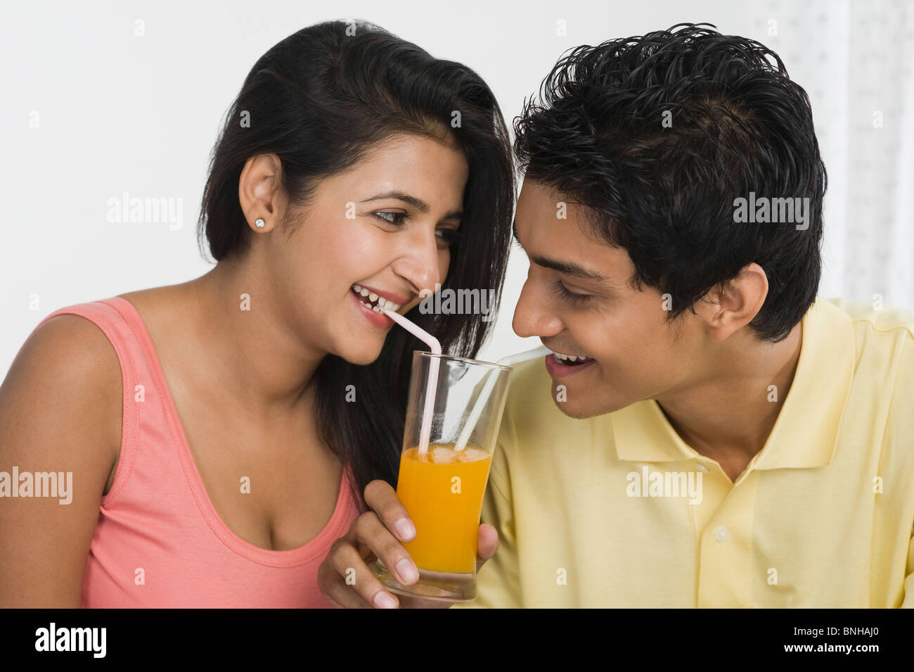 Couple sharing juice from a glass Stock Photo - Alamy