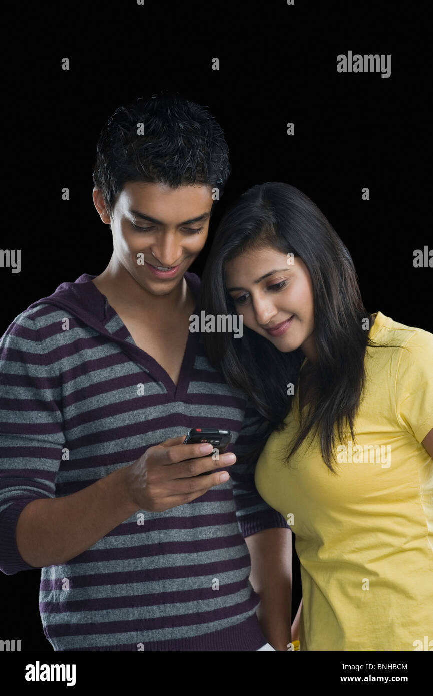 Couple looking at a mobile phone Stock Photo - Alamy