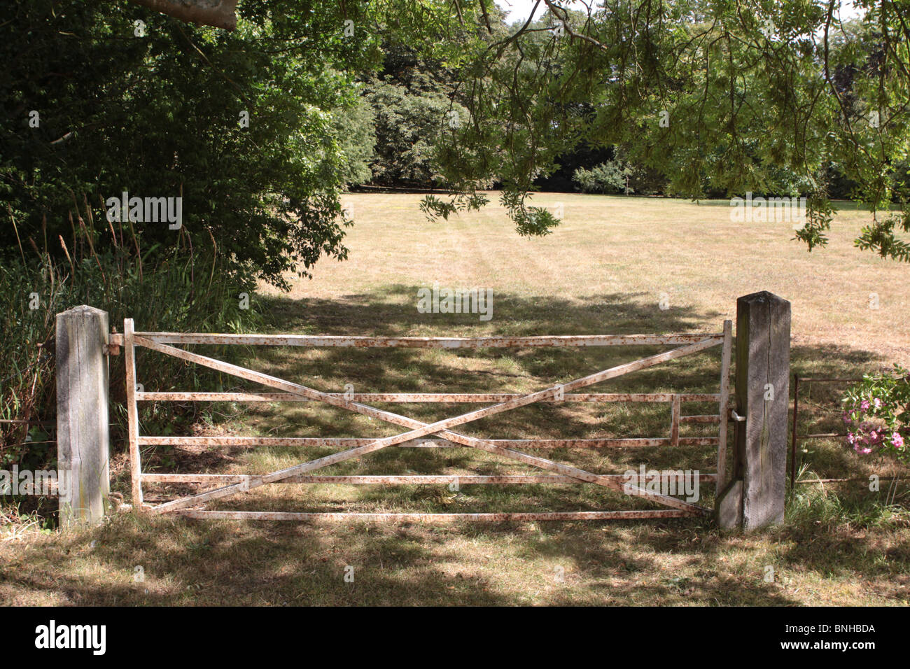 rural gate guarding the entrance to a grass field offeringconceptsof ...