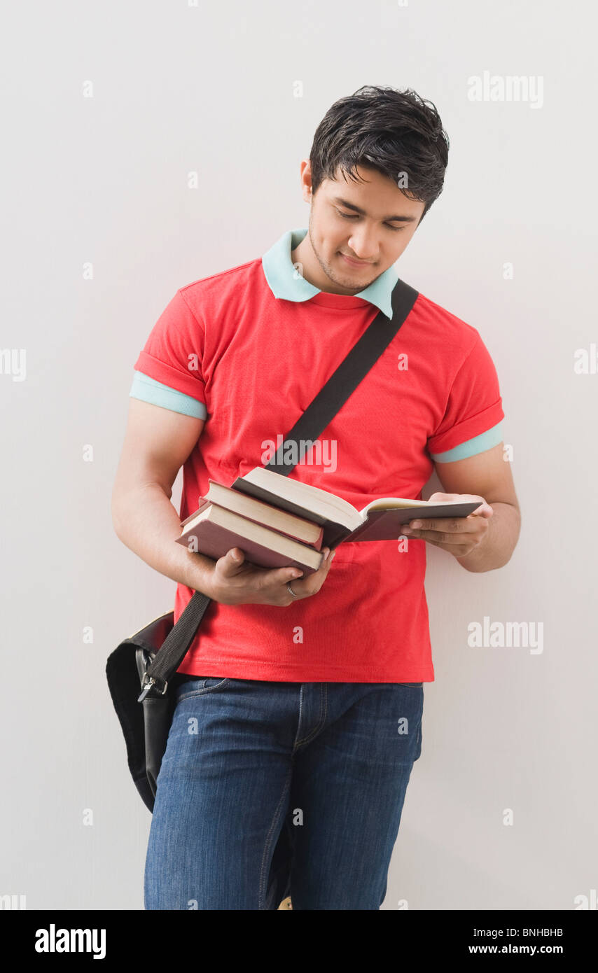 Man leaning against a wall and reading a book Stock Photo - Alamy