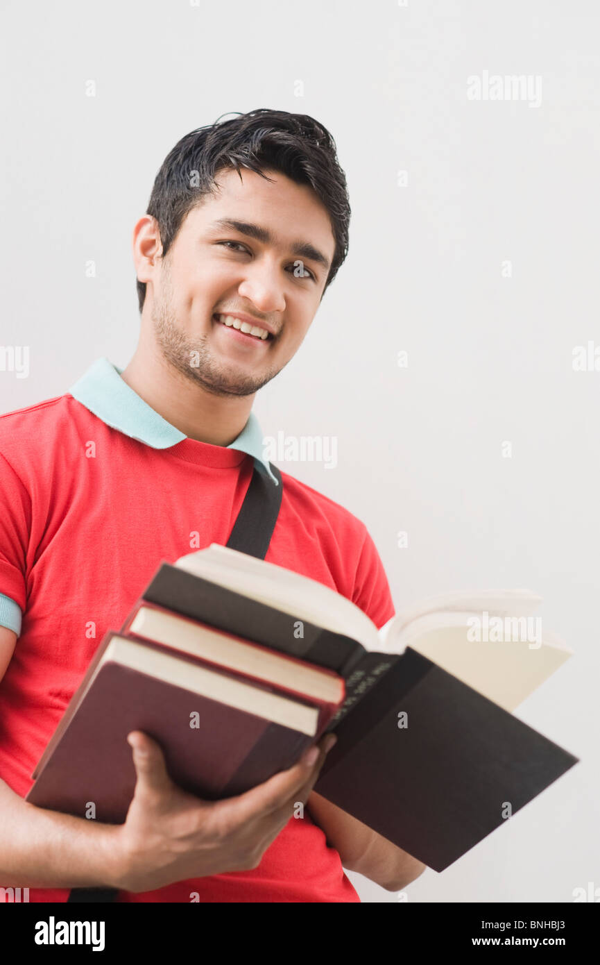 Portrait of a man holding books and smiling Stock Photo - Alamy