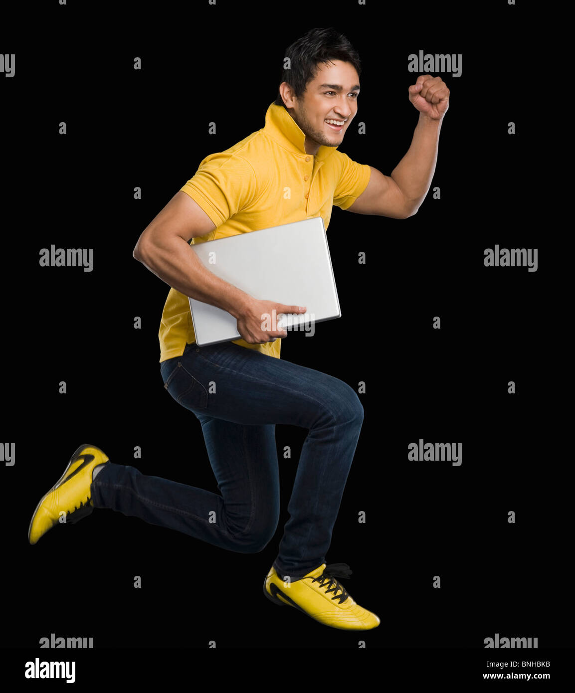 Man carrying a laptop and smiling Stock Photo - Alamy
