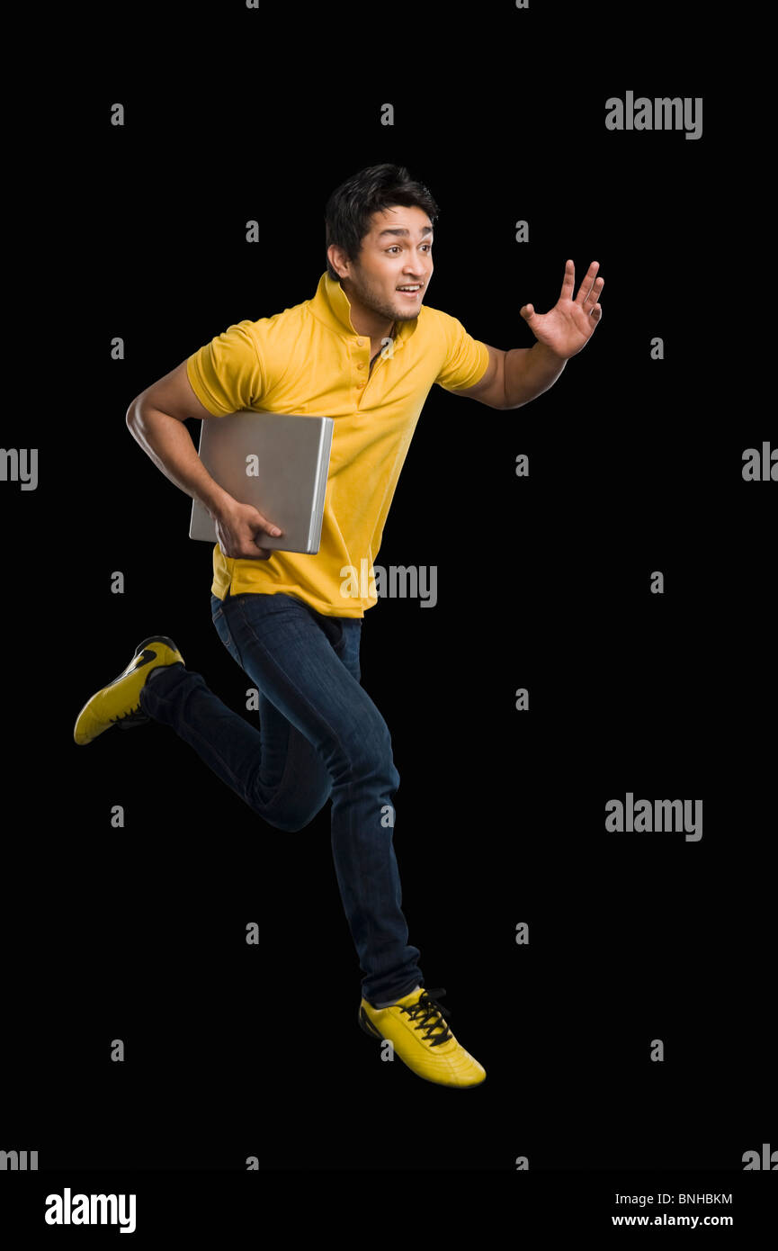 Man carrying a laptop and smiling Stock Photo - Alamy