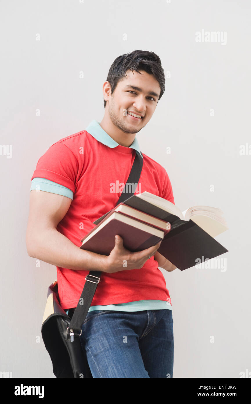 Portrait of a man holding books and smiling Stock Photo - Alamy