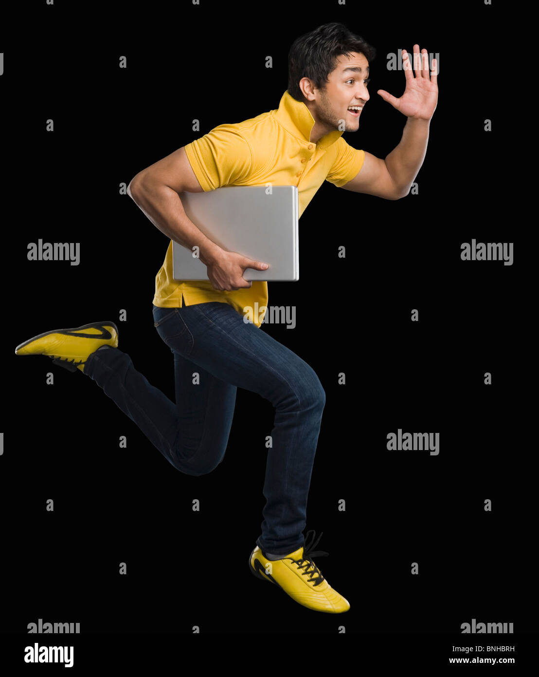 Man carrying a laptop and smiling Stock Photo - Alamy