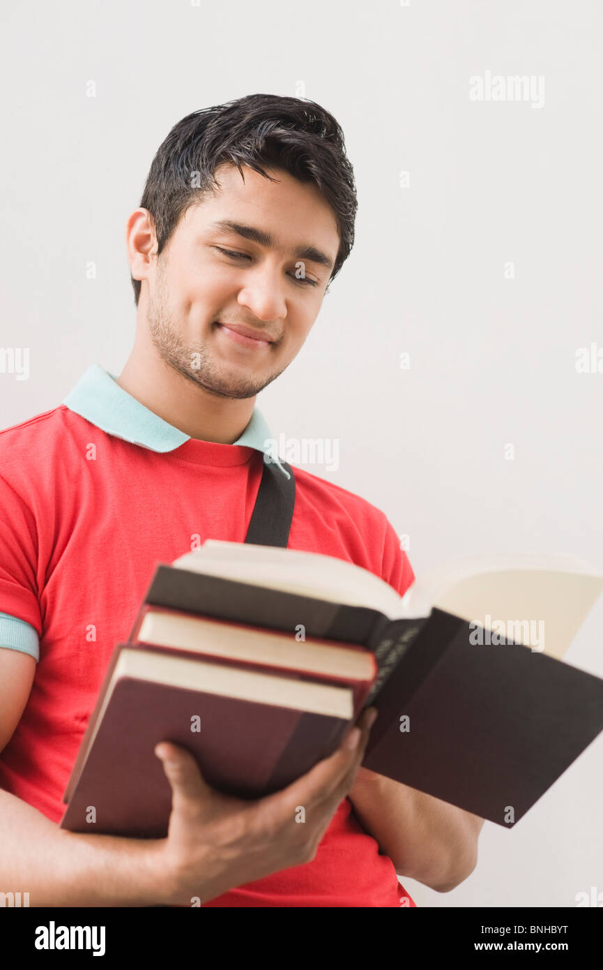 Man leaning against a wall and reading a book Stock Photo - Alamy