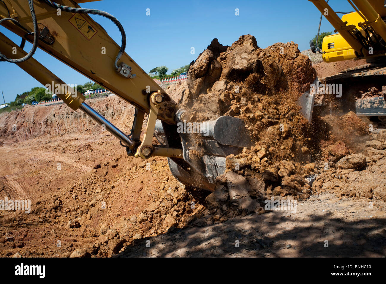 Excavator moving earth pile Stock Photo - Alamy