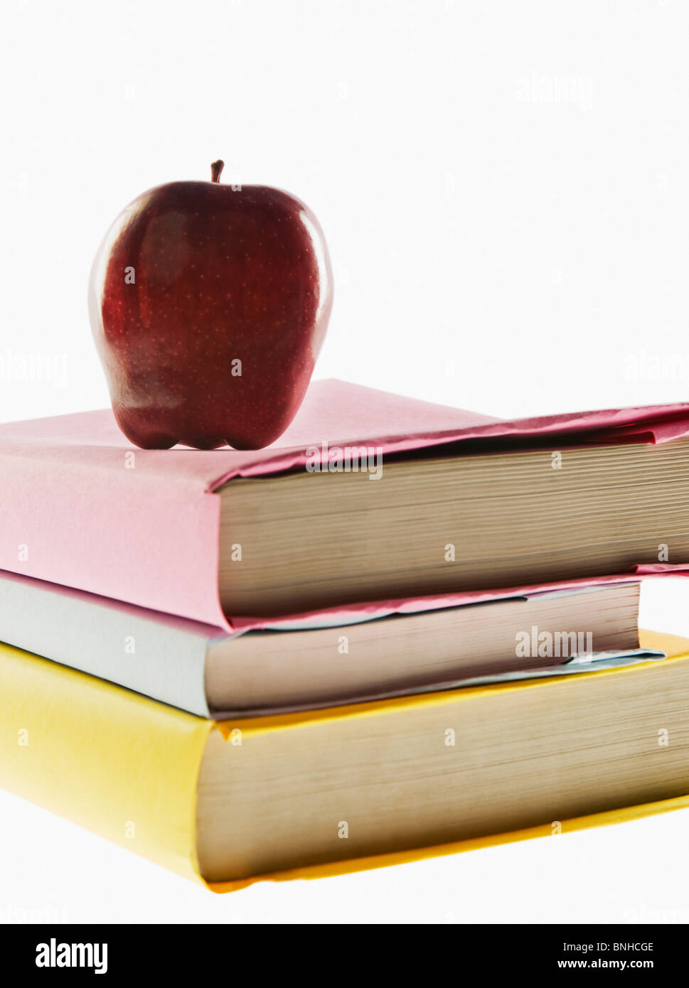 Apple on top of stacked books Stock Photo - Alamy