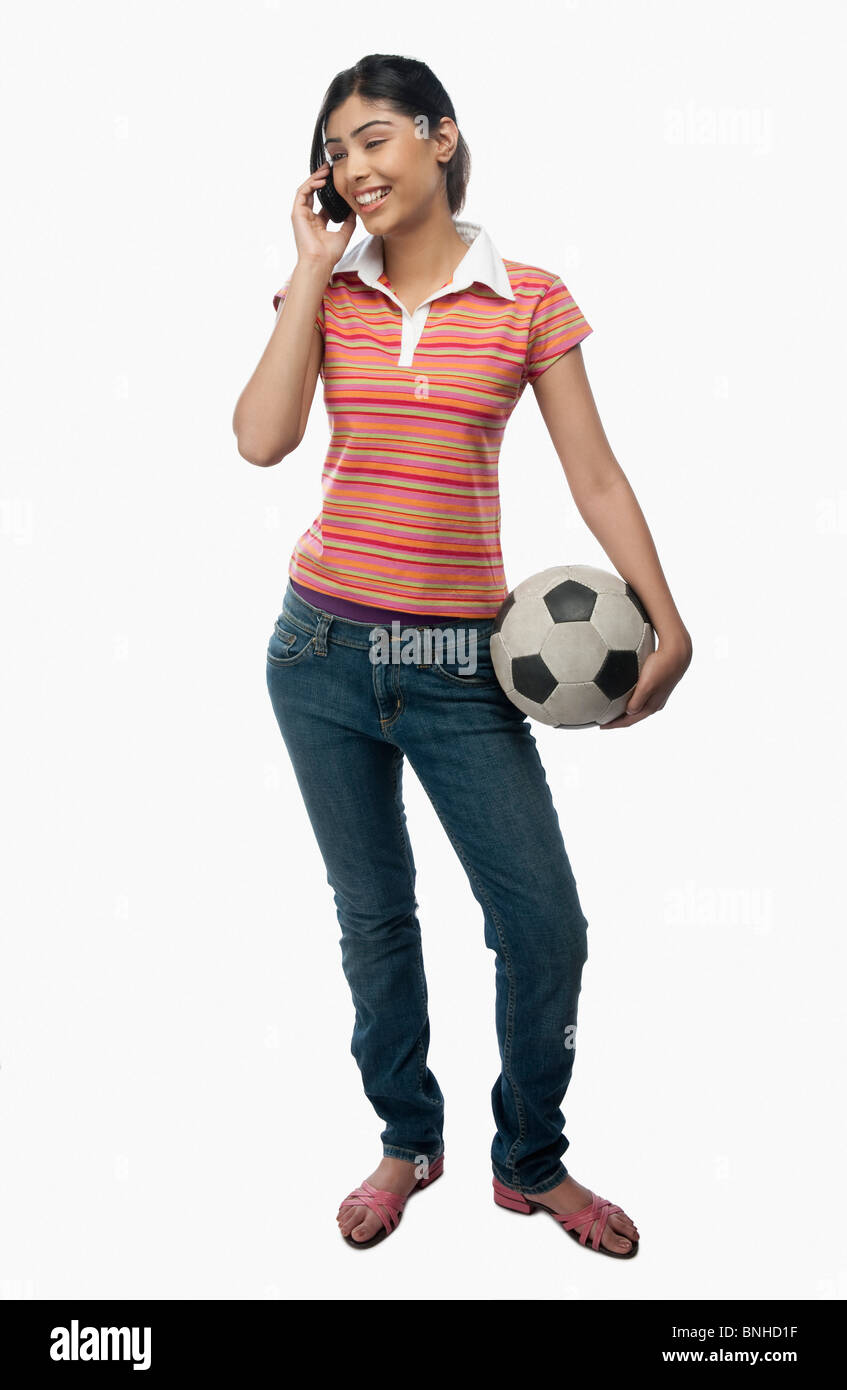 Woman talking on a mobile phone and holding a soccer ball Stock Photo ...