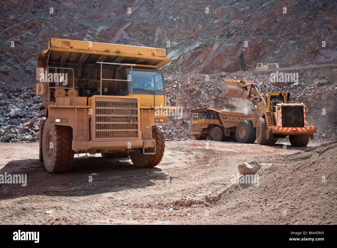 Large earth mover haul dump truck in quarry with excavator and rock ...