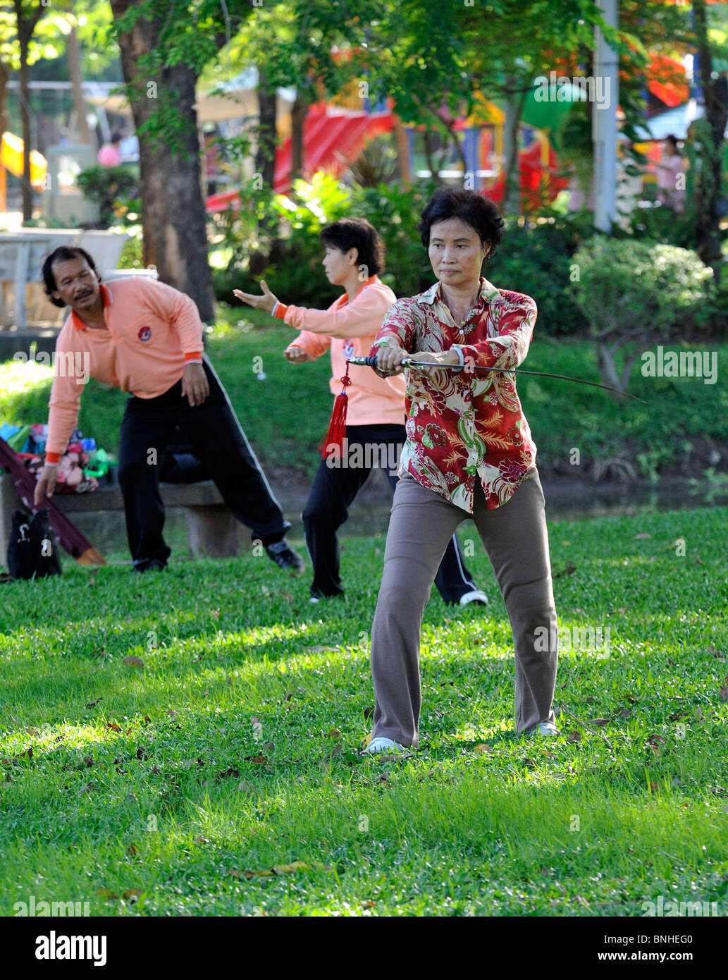 Woman performing Tai Chi exercises with a large sword in Lumpini Park ...