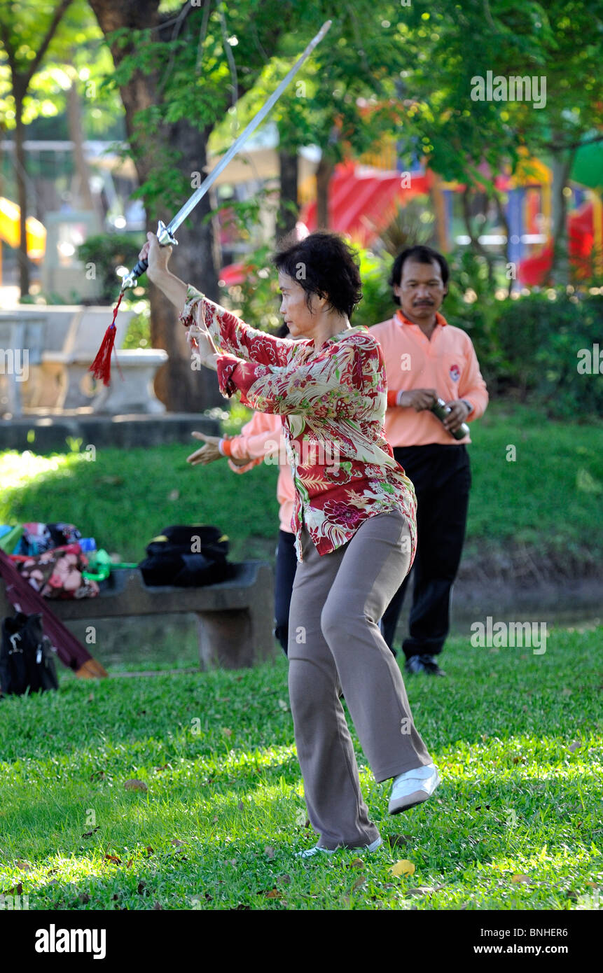 Woman performing Tai Chi exercises with a large sword in Lumpini Park ...