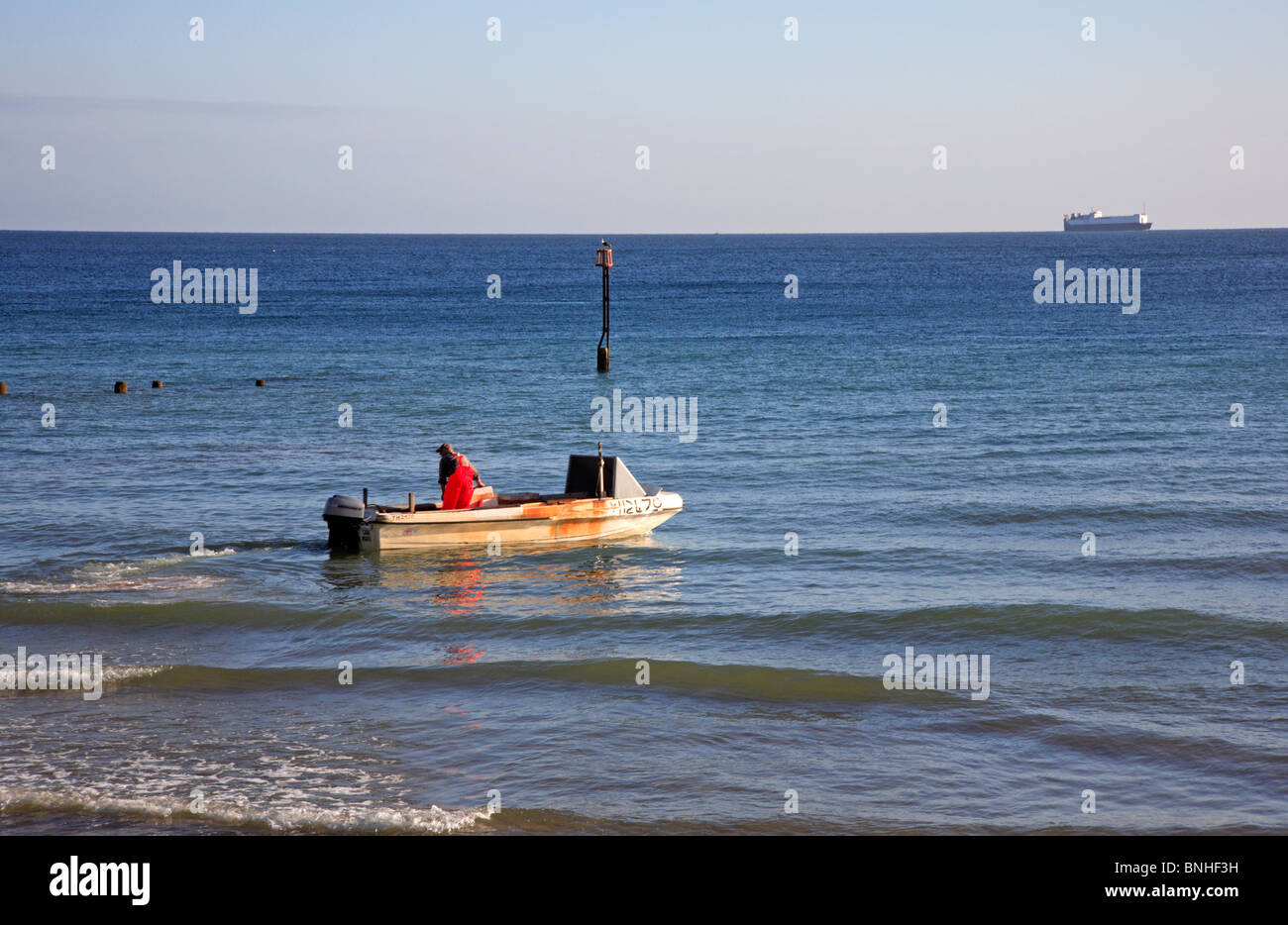 Inshore fishing boat leaving shore at Overstrand, Norfolk, England ...