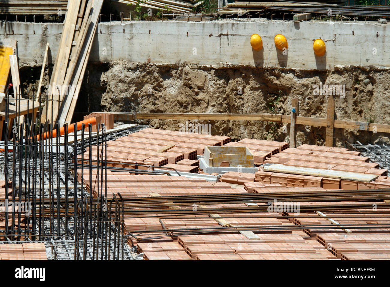 three builders protective head hard hats on wall on building site Stock ...