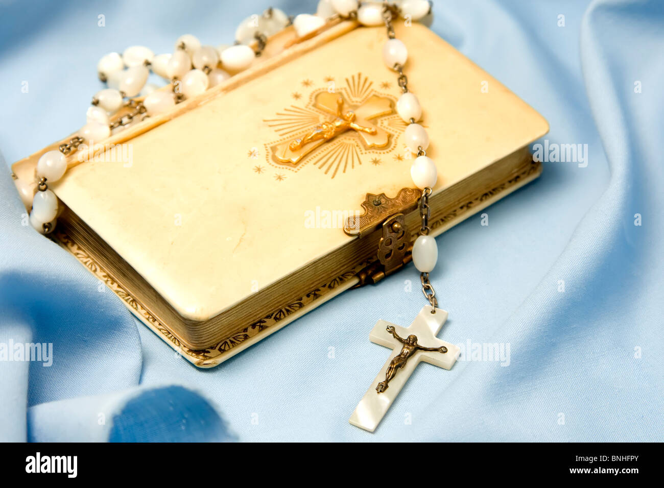 Cross and religious book over blue fabric Stock Photo - Alamy