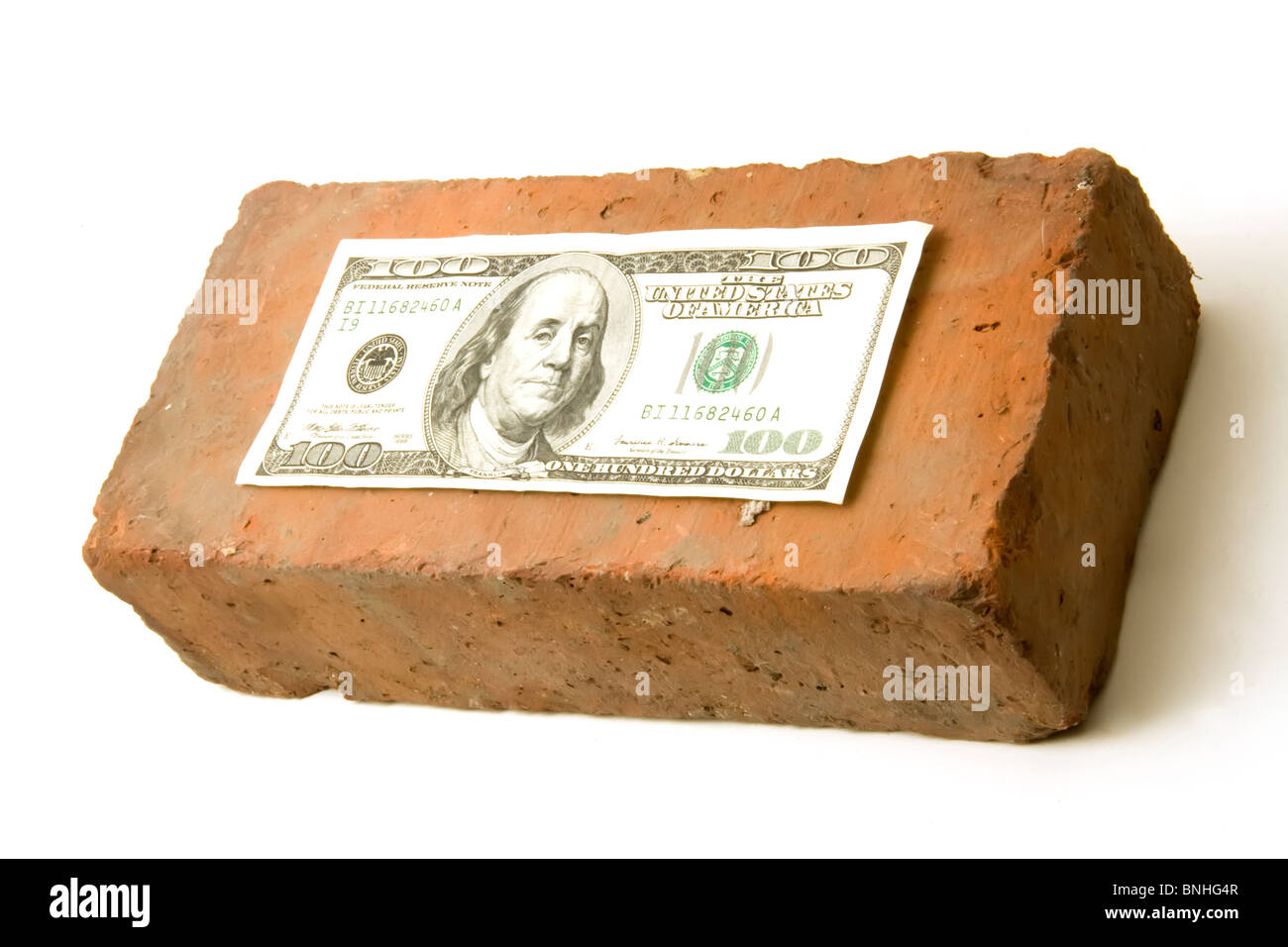 A brick with a u$s 100 bill giving the concept of expensive ...