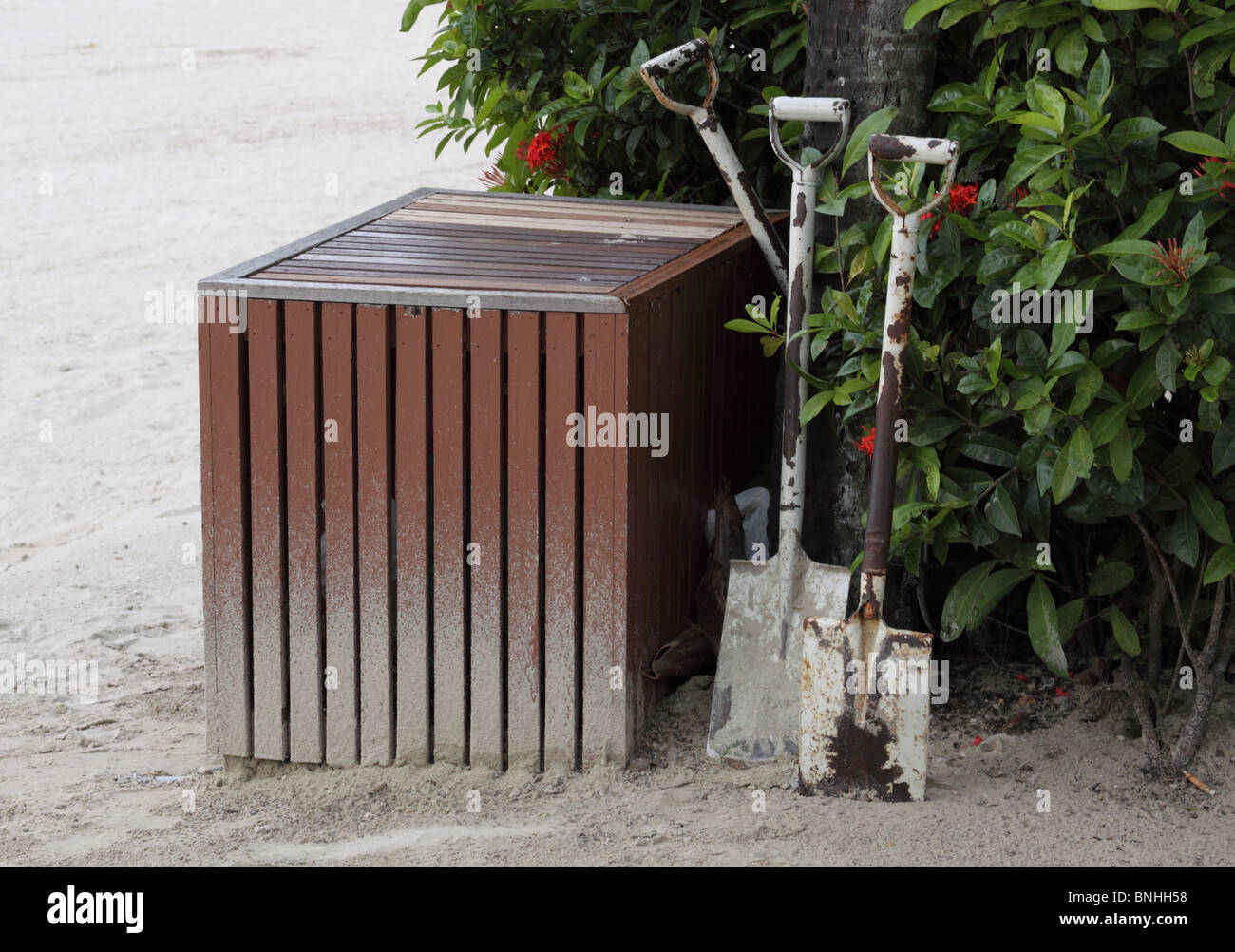 spades standing in the sand next to a paneled box Stock Photo - Alamy