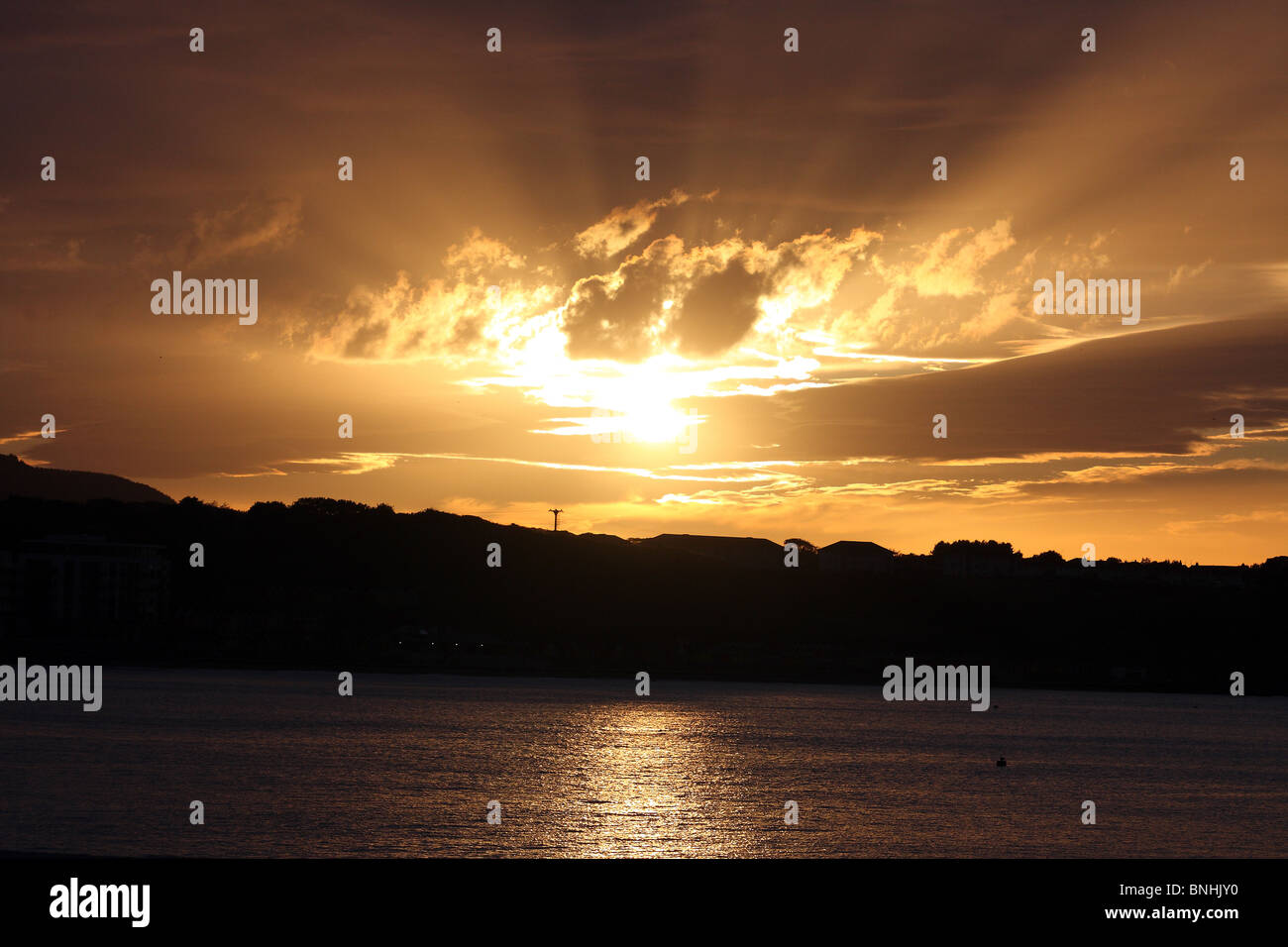 The sun setting at night over Scarborough beach and coastline, with a ...