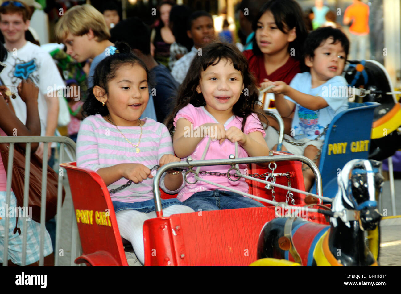 2 children playing on a carnival ride Stock Photo - Alamy
