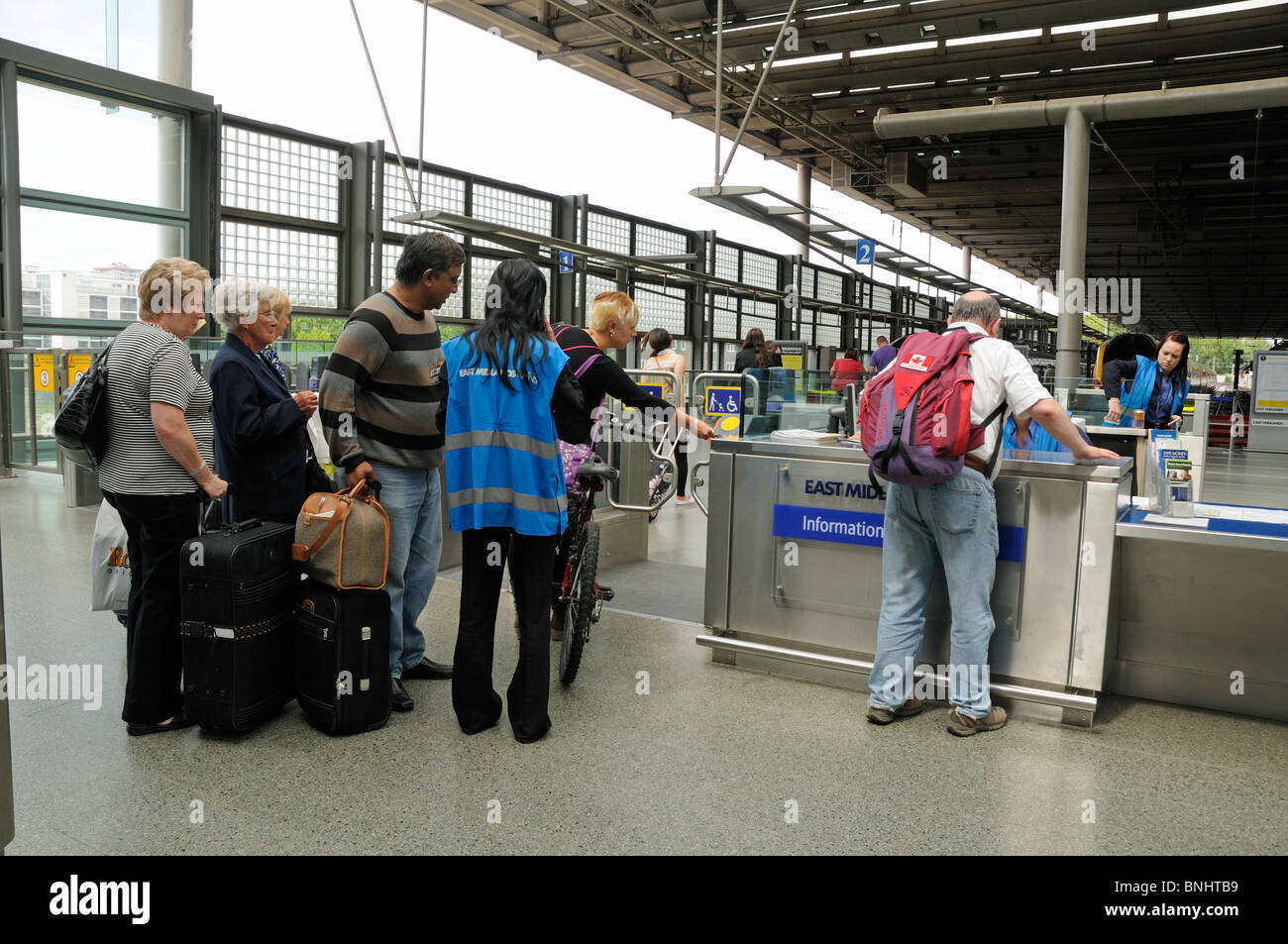 Passengers queuing to get through ticket barrier, East Midland Trains ...
