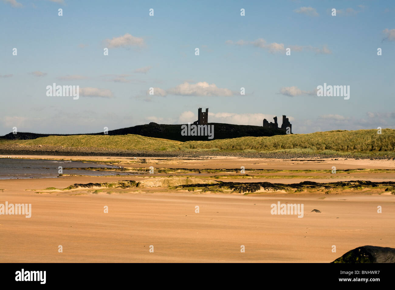 Shadow over Dunstanburgh Castle from the sandy beach at Embleton Bay ...