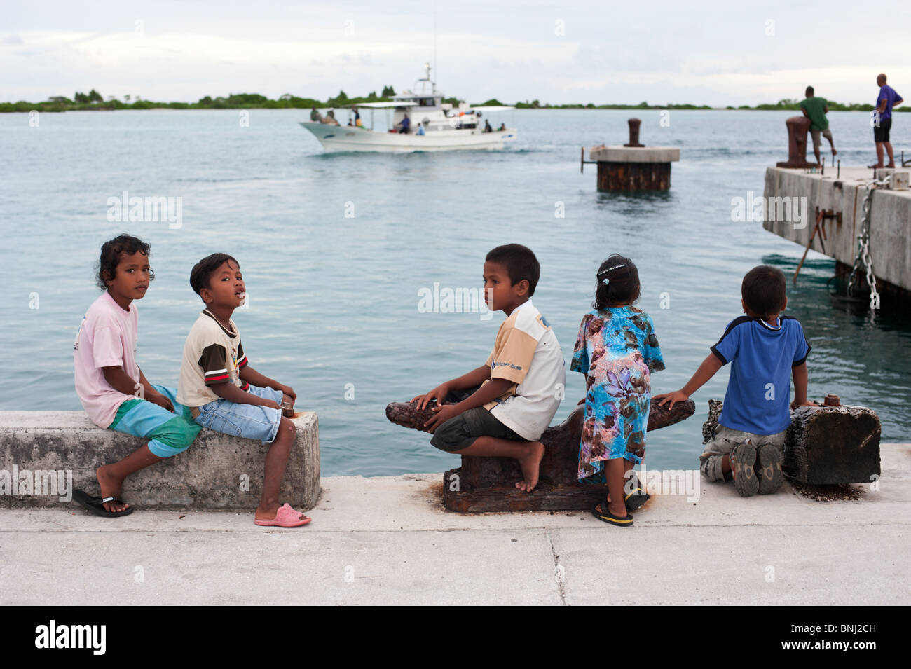 Marshallese children waiting on the Jaluit Pier for the fishing boat to ...