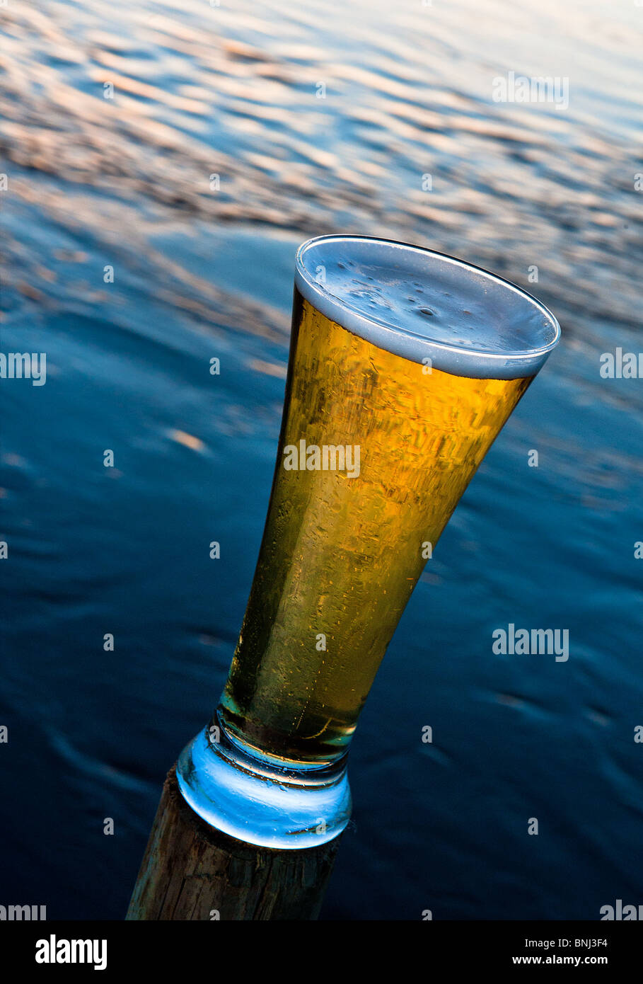 a glass of cold beer placed at the waters edge Stock Photo - Alamy