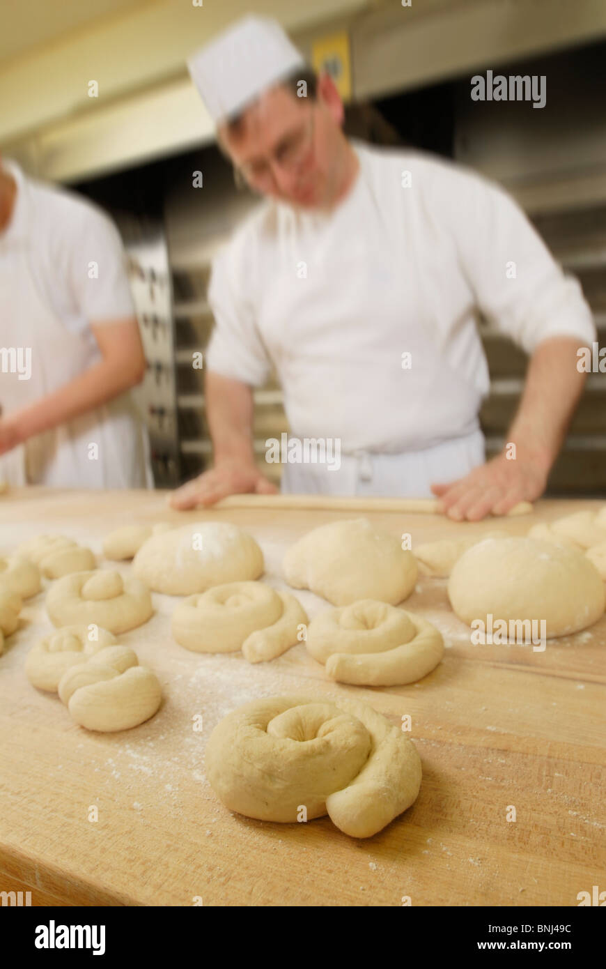 baker, blurred, forming cakes out of pastry Stock Photo - Alamy