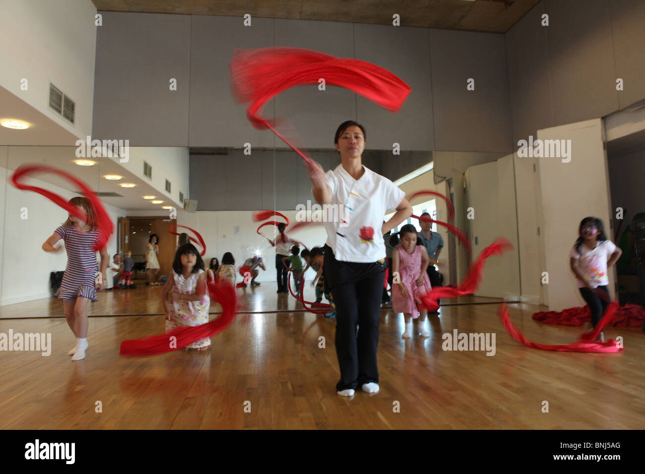 a oriental woman doing a traditional ribbon dance in a dance studio ...