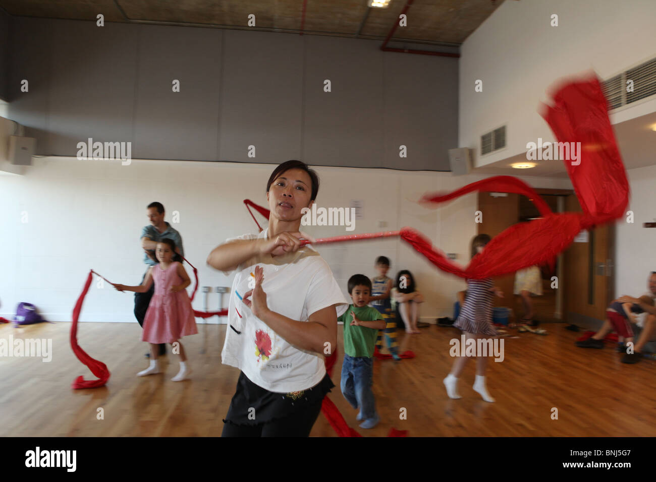 a oriental woman doing a traditional ribbon dance in a dance studio ...