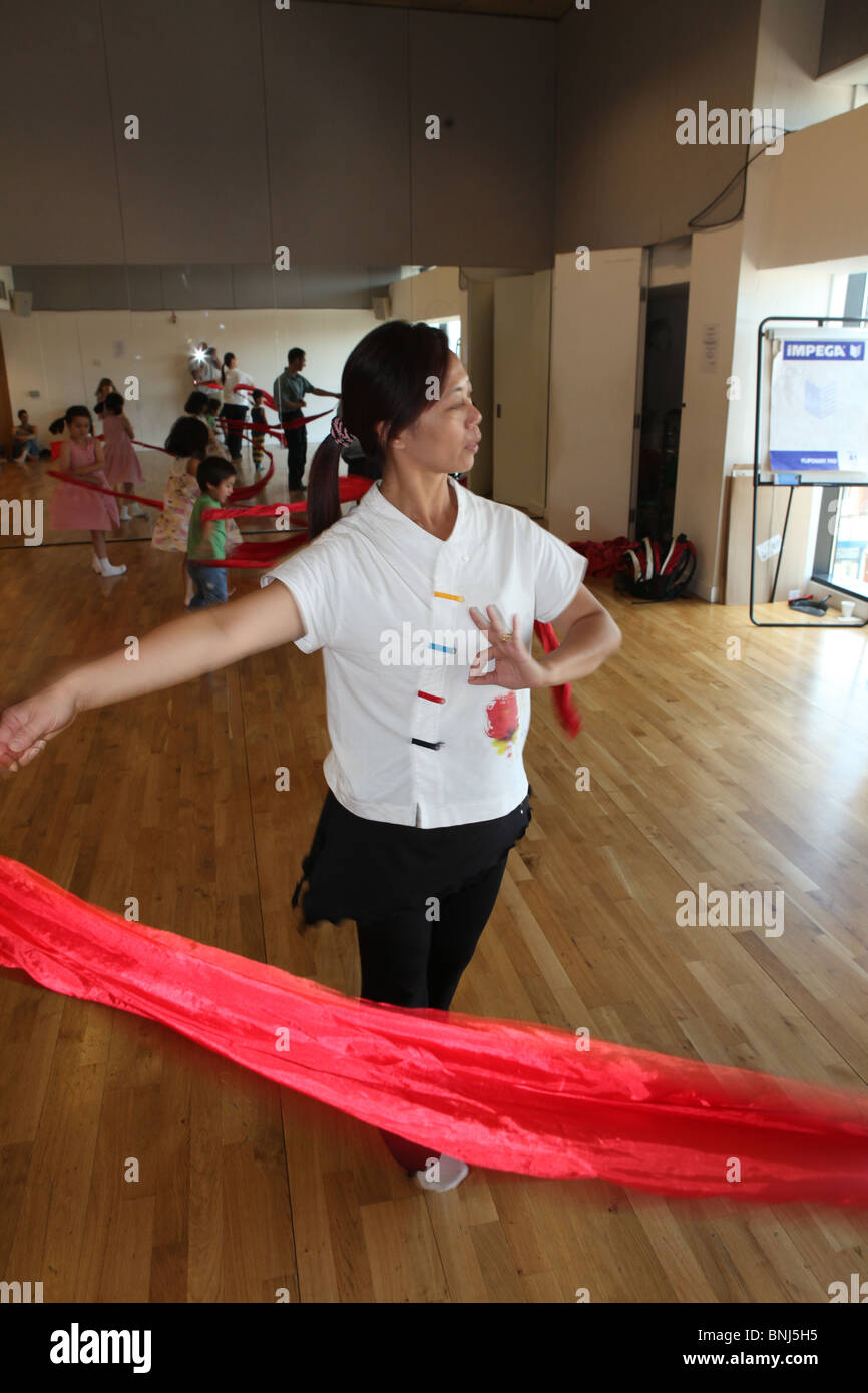 a oriental woman doing a traditional ribbon dance in a dance studio ...