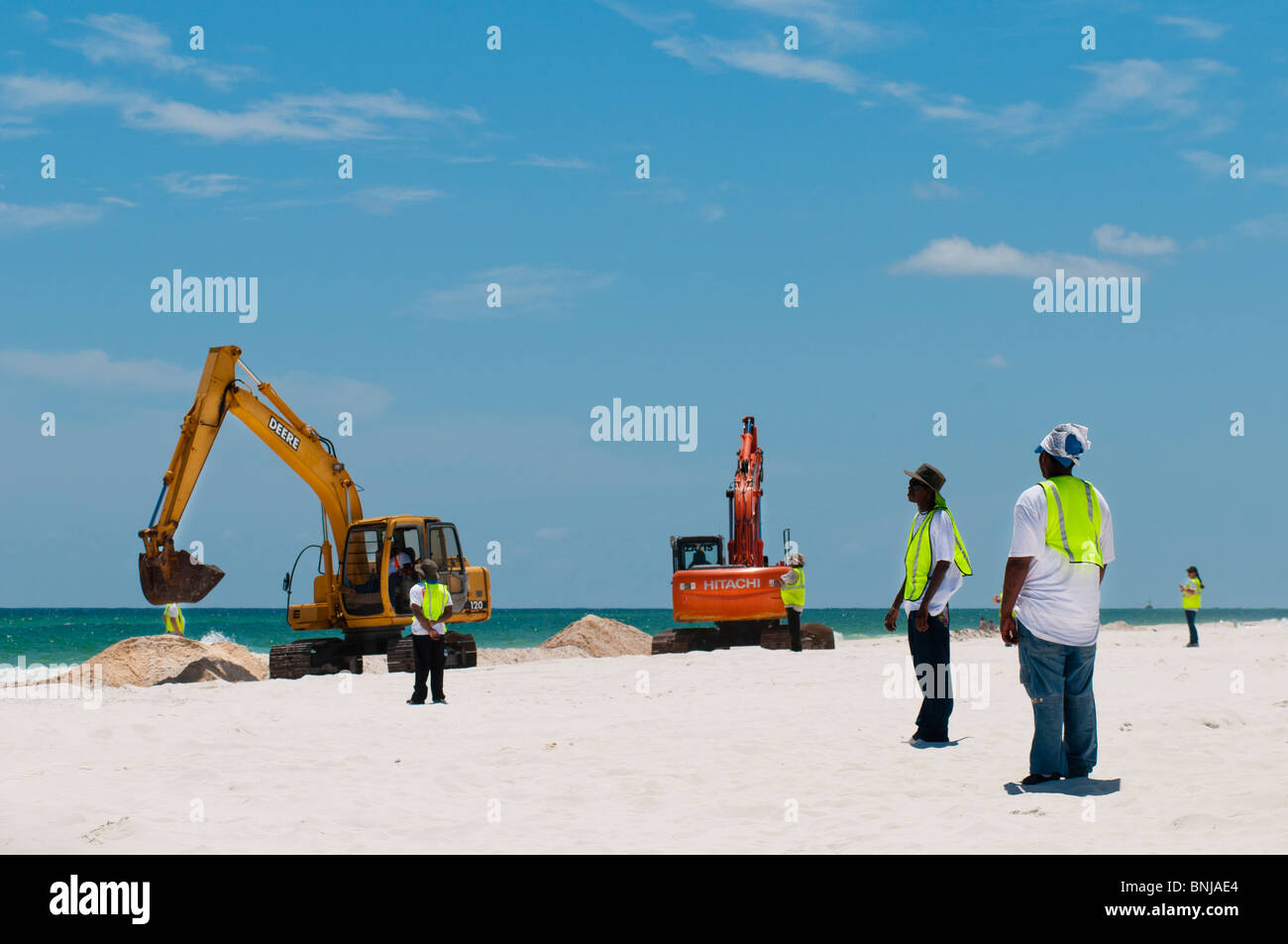Heavy equipment digging trenches in sand to determine the depth of oil ...