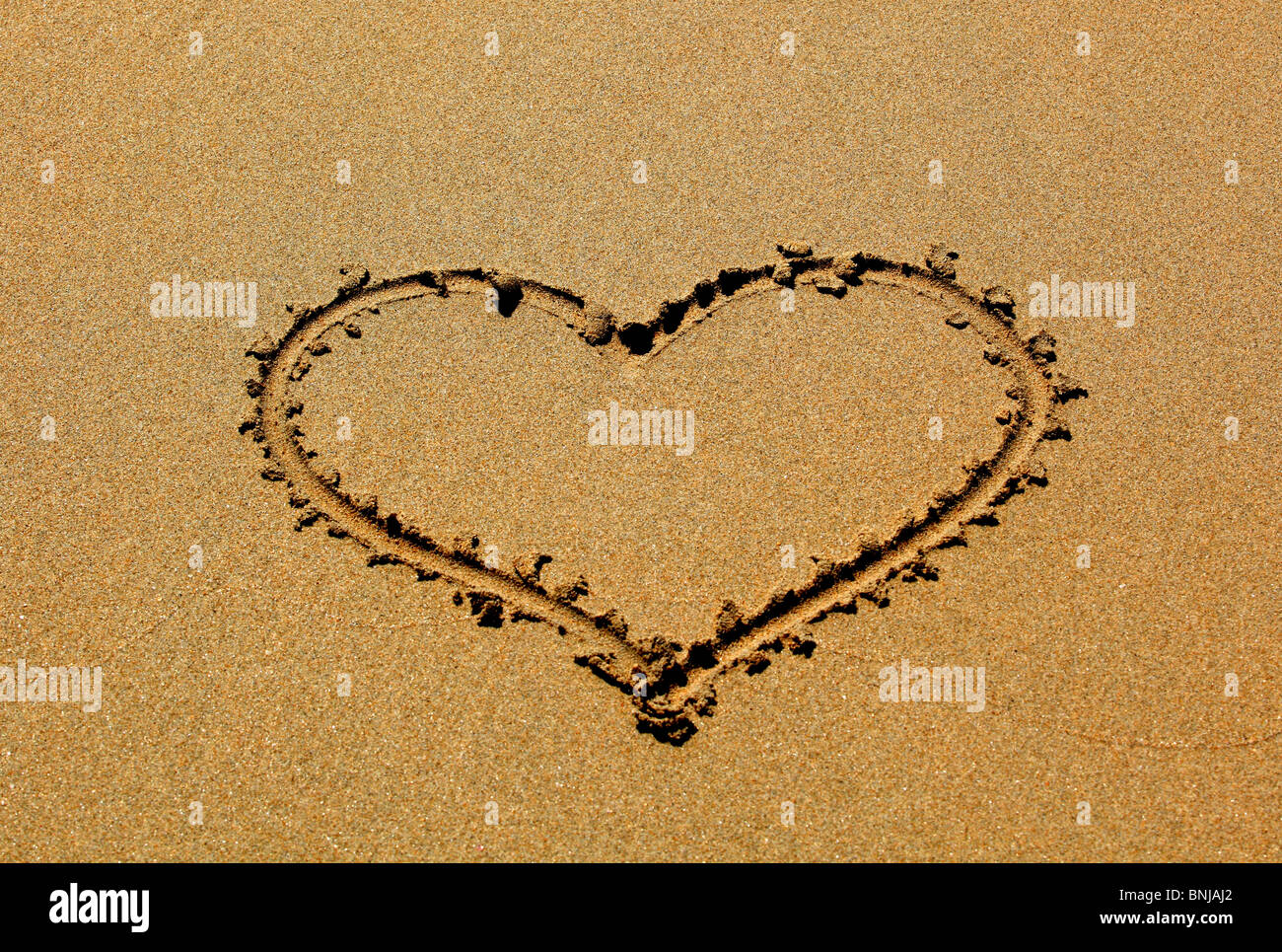 Heart shape in the sand Stock Photo - Alamy