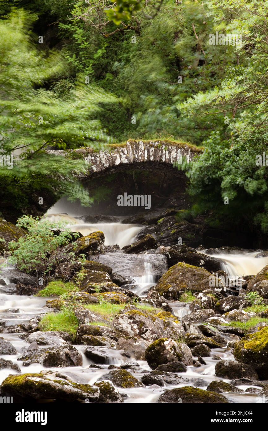Stone bridge over fast flowing river Stock Photo - Alamy