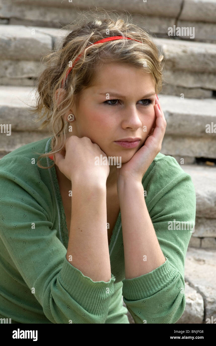 Teenage girl looking cross with head in hands Stock Photo - Alamy