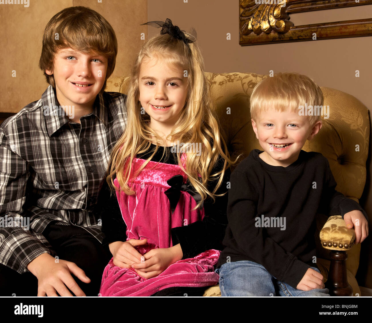 Portrait of a three beautiful brothers and sister in formal interior ...