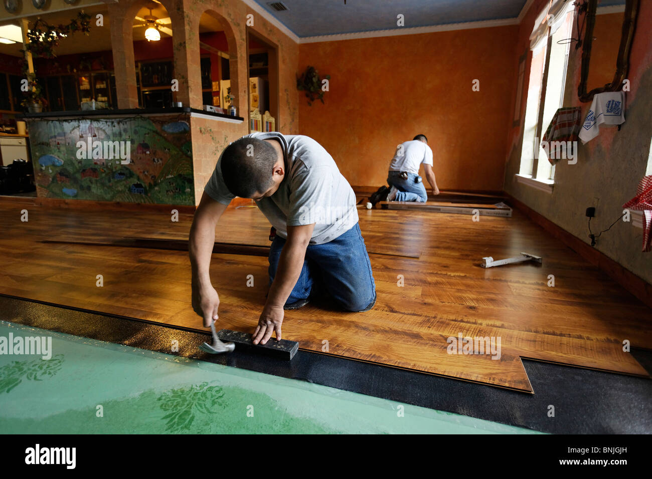 laying new laminate floor flooring worker workers man men indoor ...