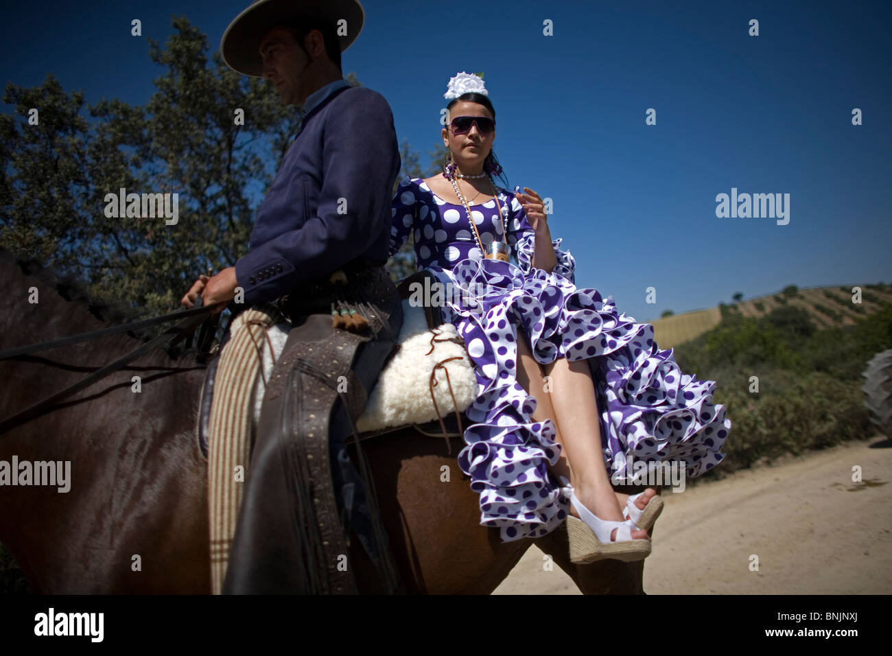 Riders wear traditional Andalusian clothes during a romeria, or ...