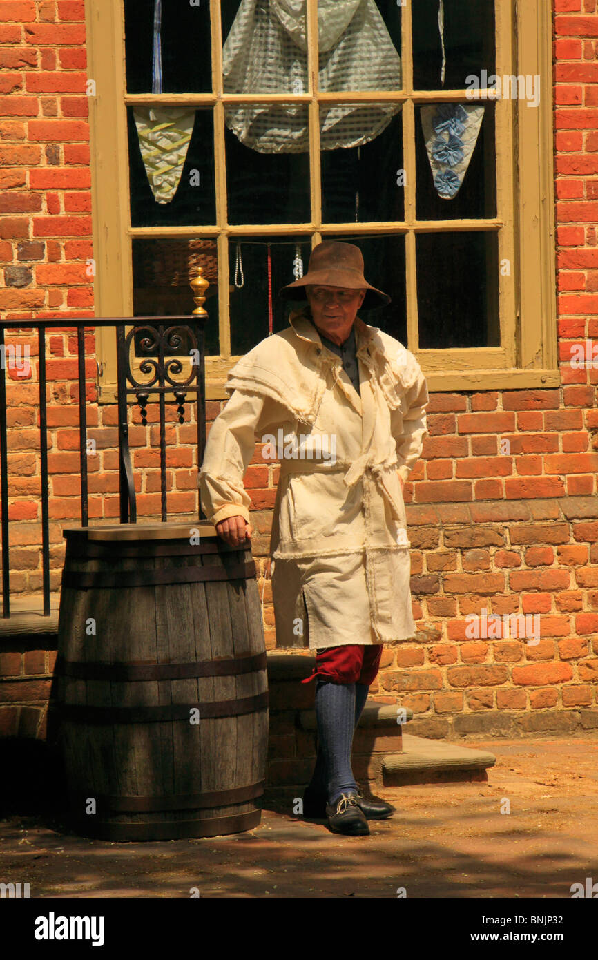 A costumed Interpreter stands outside his shop in the Historic Area ...