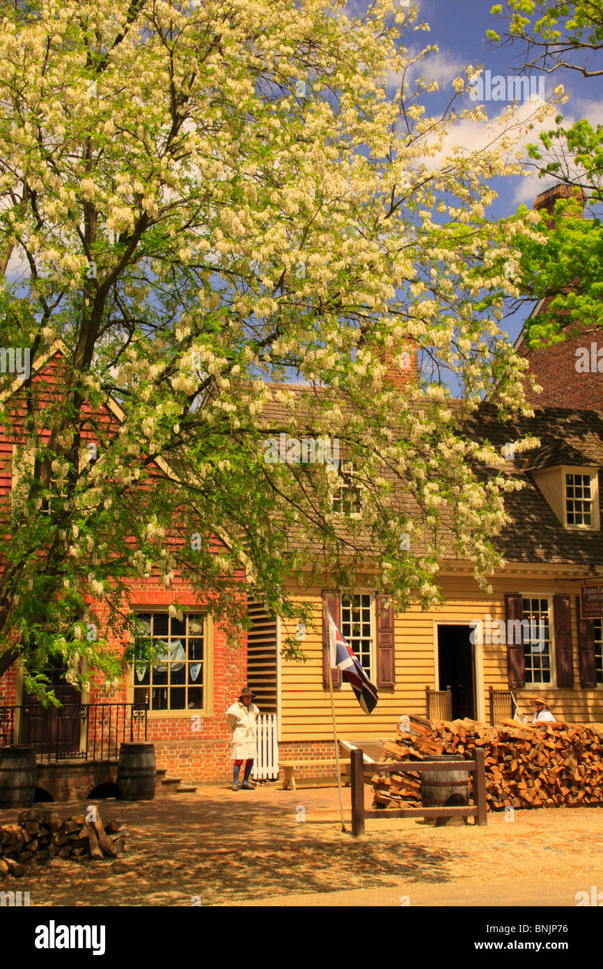 A costumed Interpreter stands outside his shop in the Historic Area ...