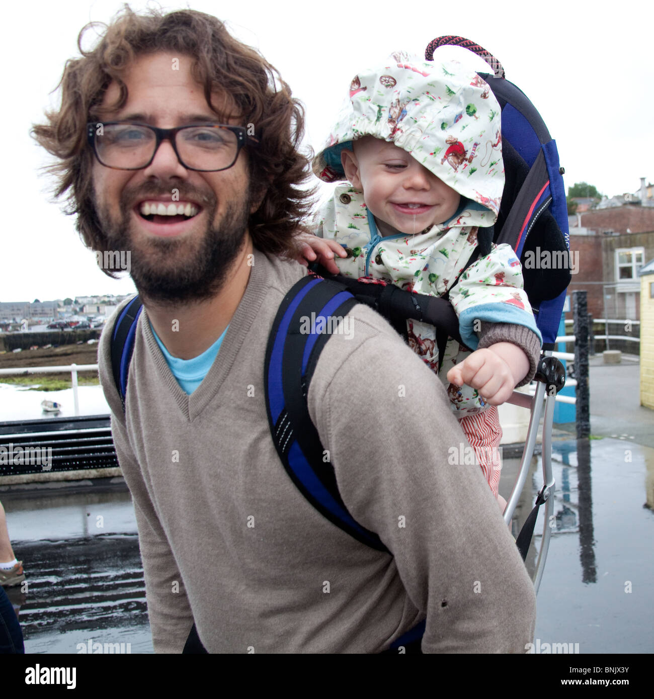 Man carrying a baby boy in a rucksack style baby carrier, Falmouth ...