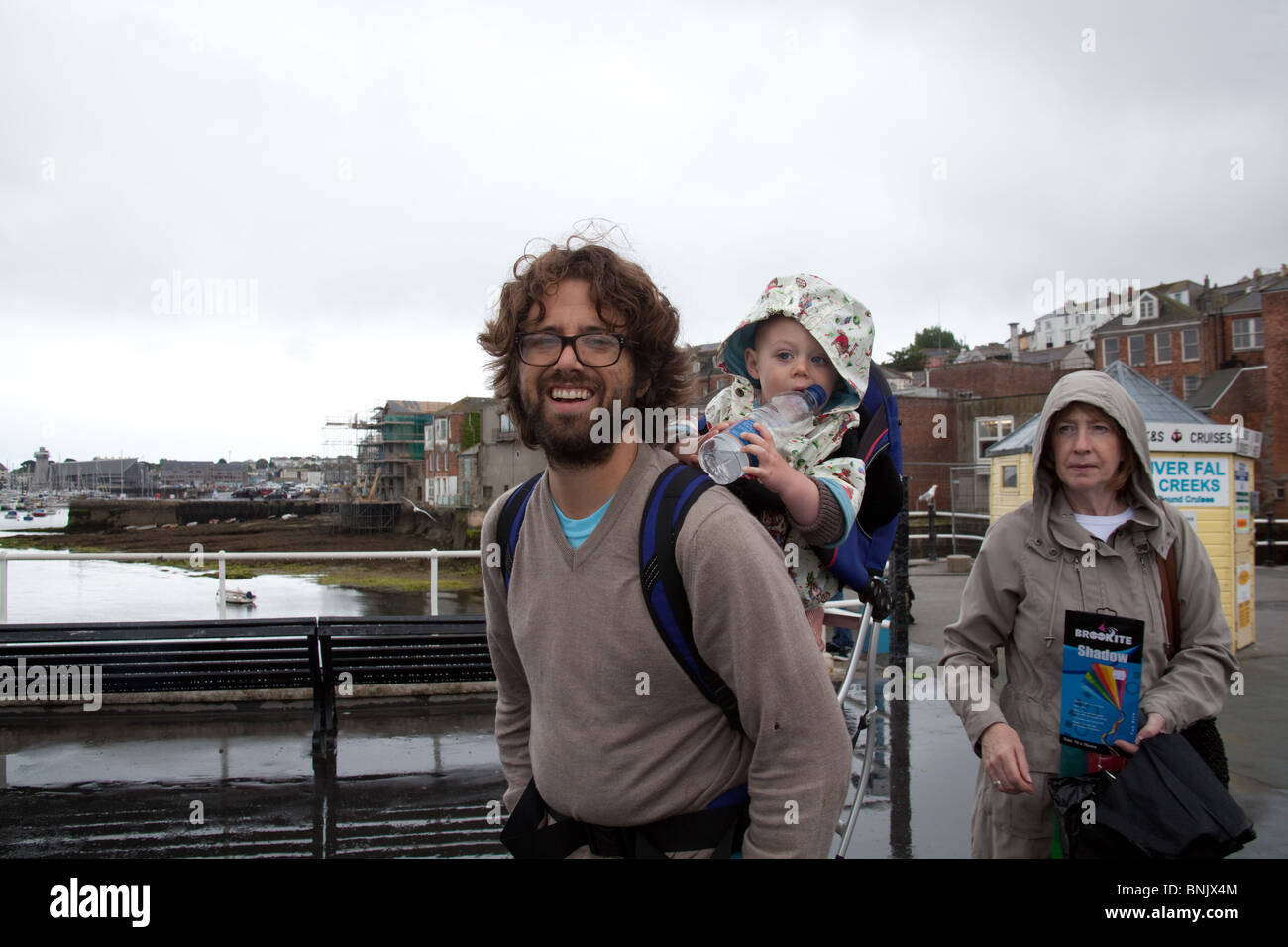 Man carrying a baby boy in a rucksack style baby carrier, Falmouth ...