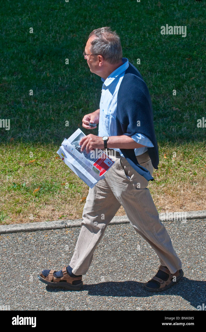 Mature / middle-aged man walking along pavement - France Stock Photo ...