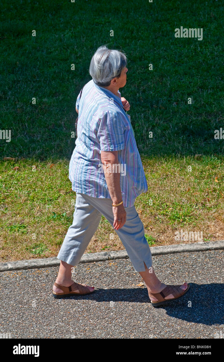 Mature / middle-aged woman walking along pavement - France Stock Photo ...
