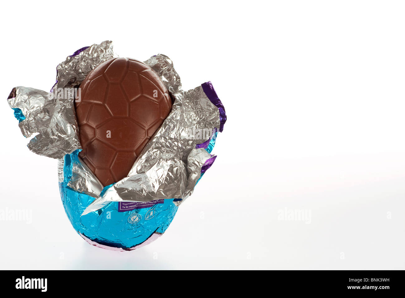 Milk chocolate Easter egg with silver & blue foil wrapper on white ...