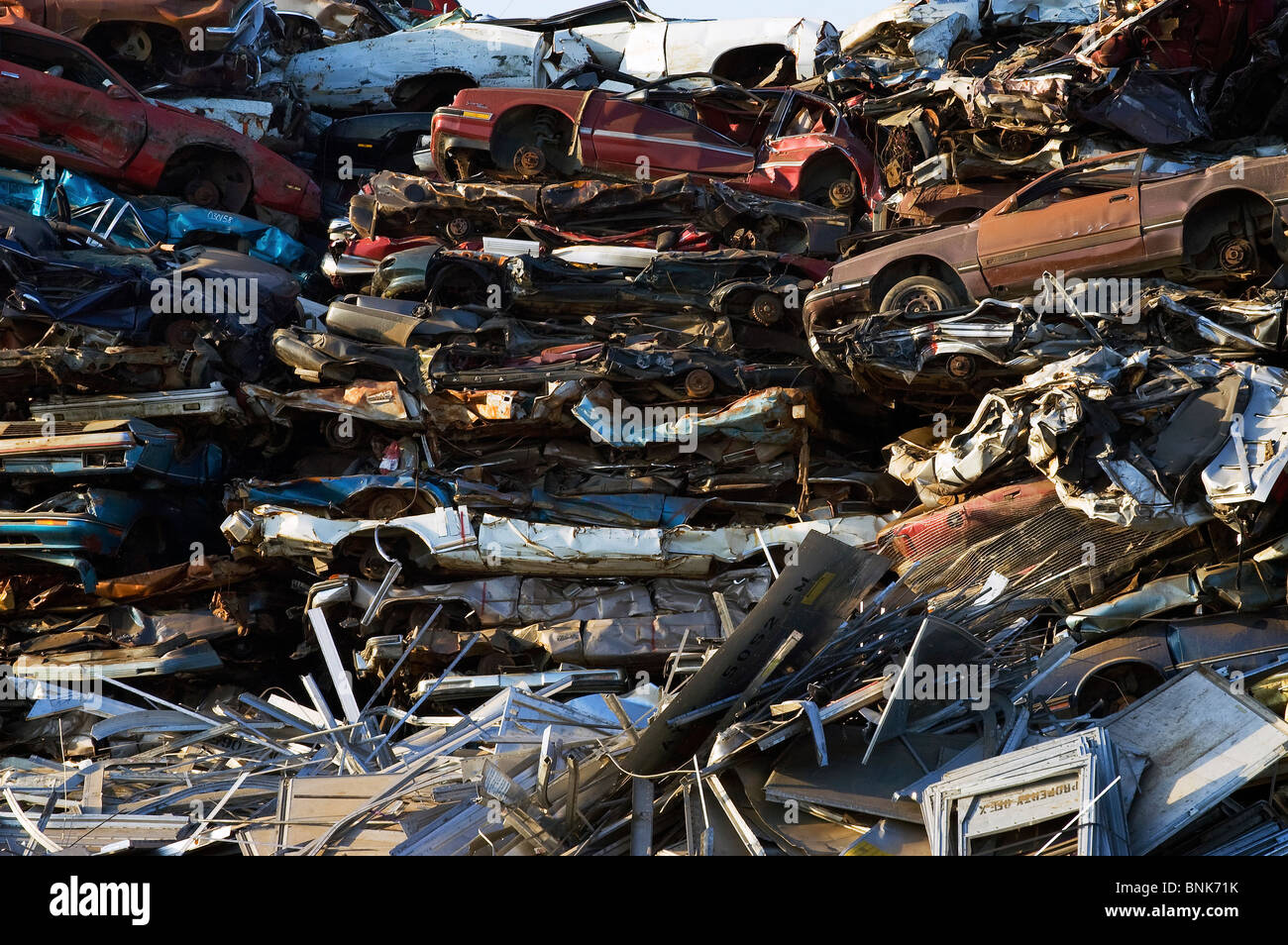 Crushed cars are stacked high, ready to be recycled in the pulverizer ...