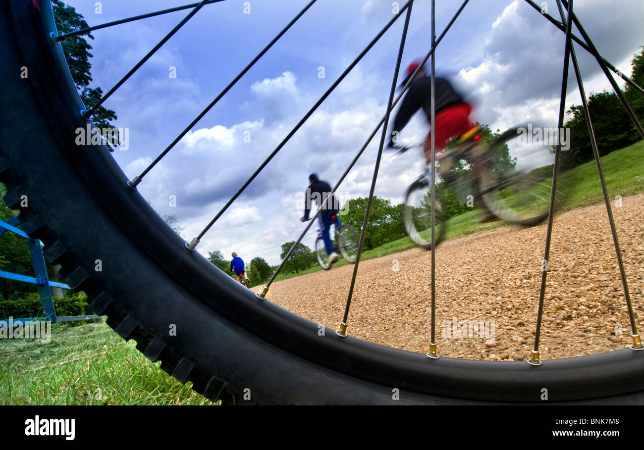 Cyclists cycling pathway outdoors enjoying a ride in a local park ...