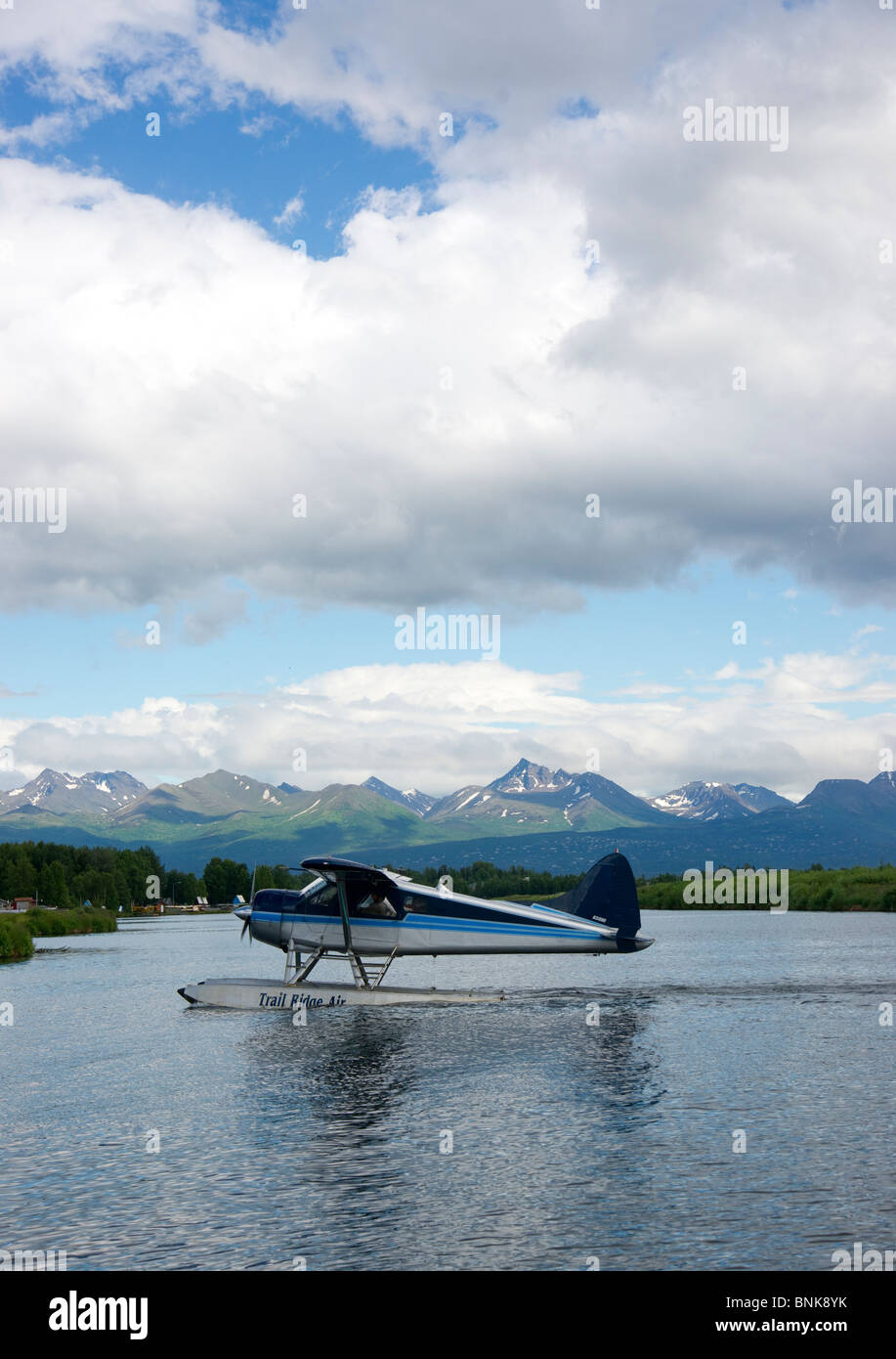Pontoon Plane flies from Lake Hood in Anchorage, framed by the Chugach ...