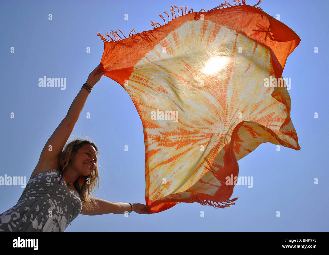Girl shaking sand from a sarong at the beach Stock Photo - Alamy