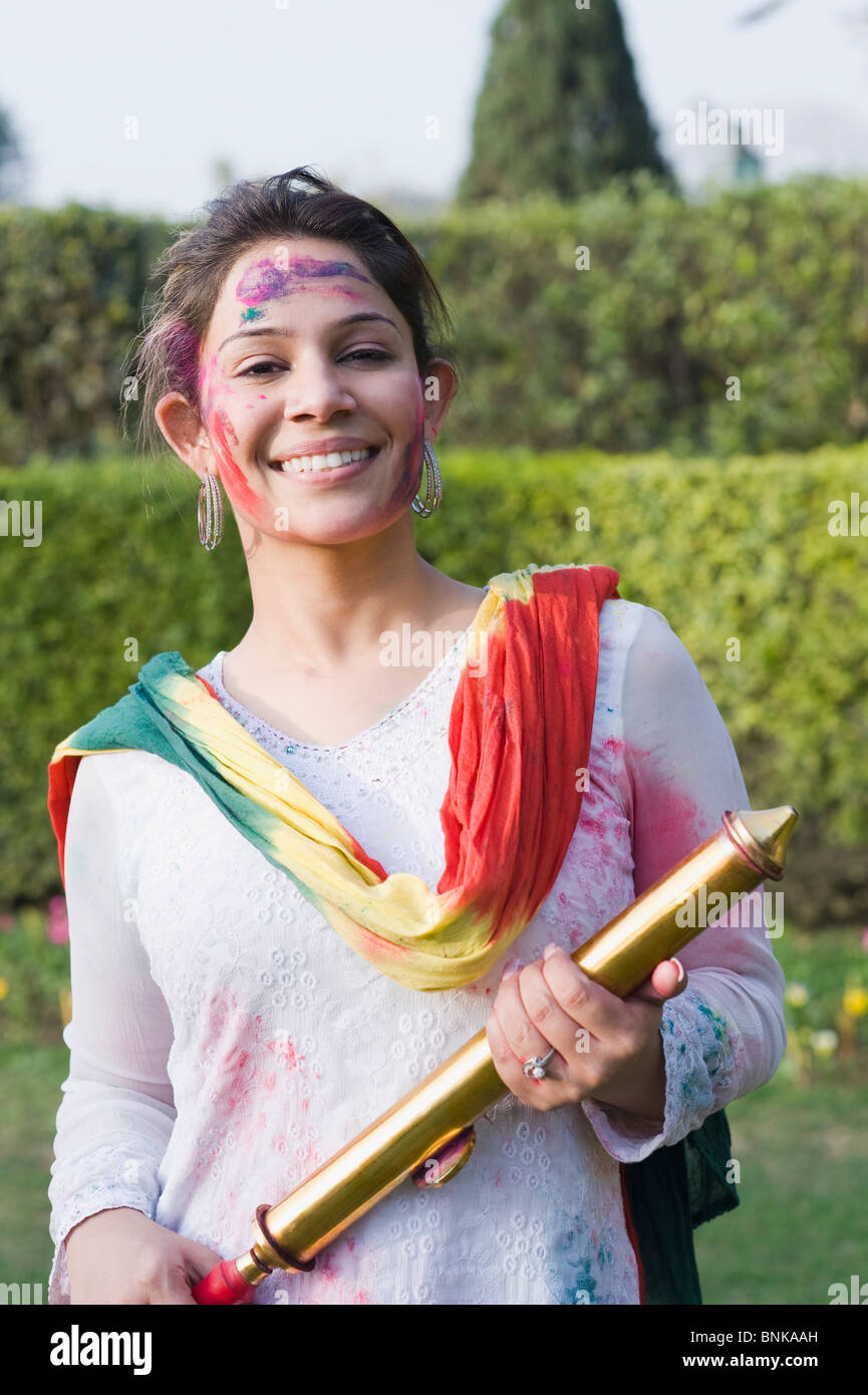 Woman holding a pichkari and celebrating Holi Stock Photo - Alamy